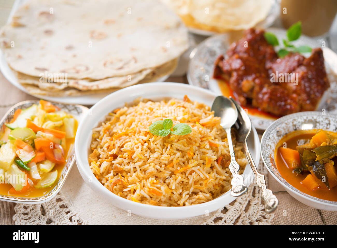 Indian meal biryani rice, chicken curry, masala milk tea, acar ...