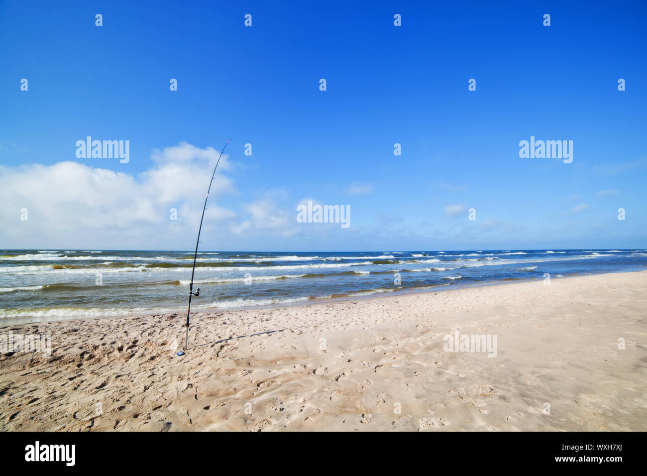 Fishing rod on the beach. Fishing in the sea. Blue sky Stock Photo - Alamy