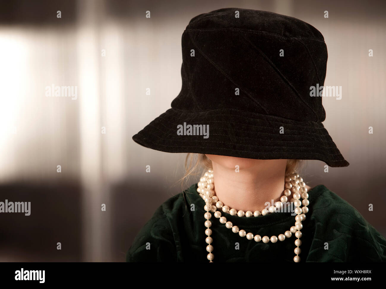 Funny young girl with her face hidden in her hat Stock Photo - Alamy