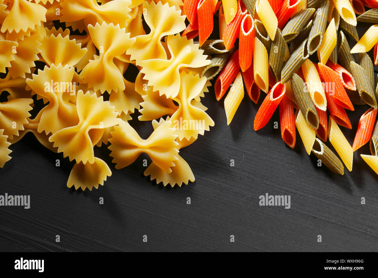 Variety of types and shapes of Italian pasta on black table Stock Photo ...
