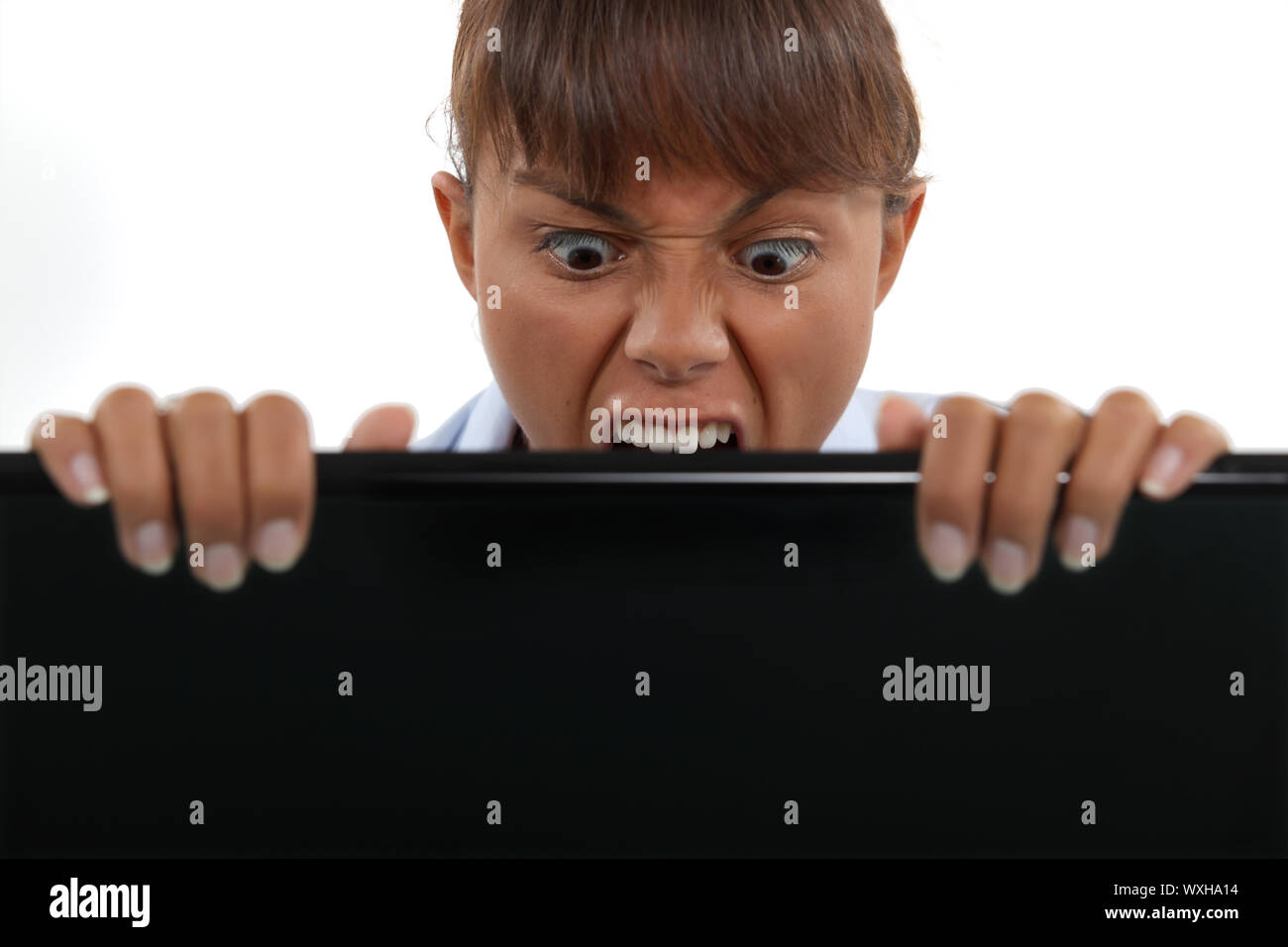 Businesswoman biting laptop screen Stock Photo - Alamy