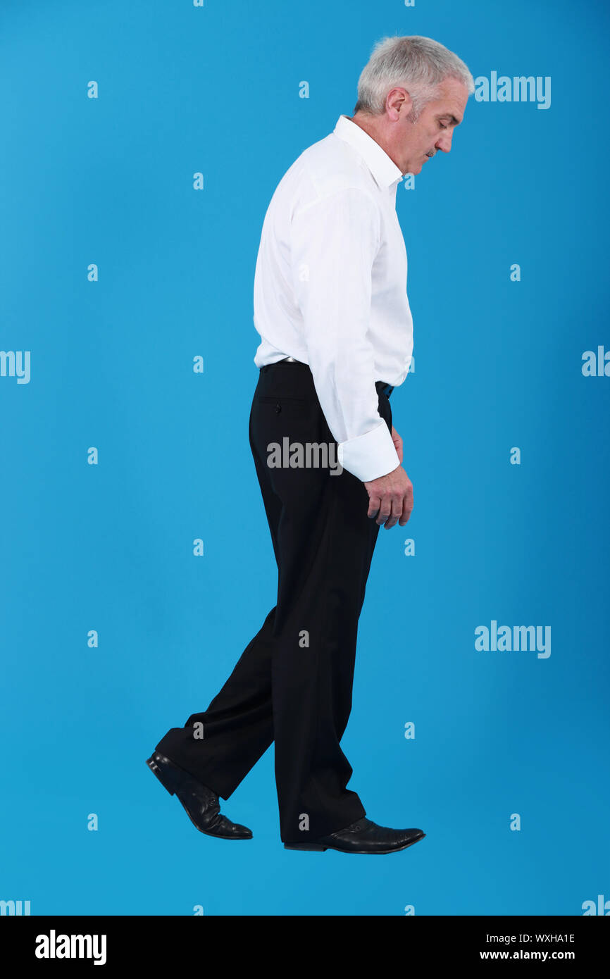 Man looking at the ground while walking Stock Photo - Alamy
