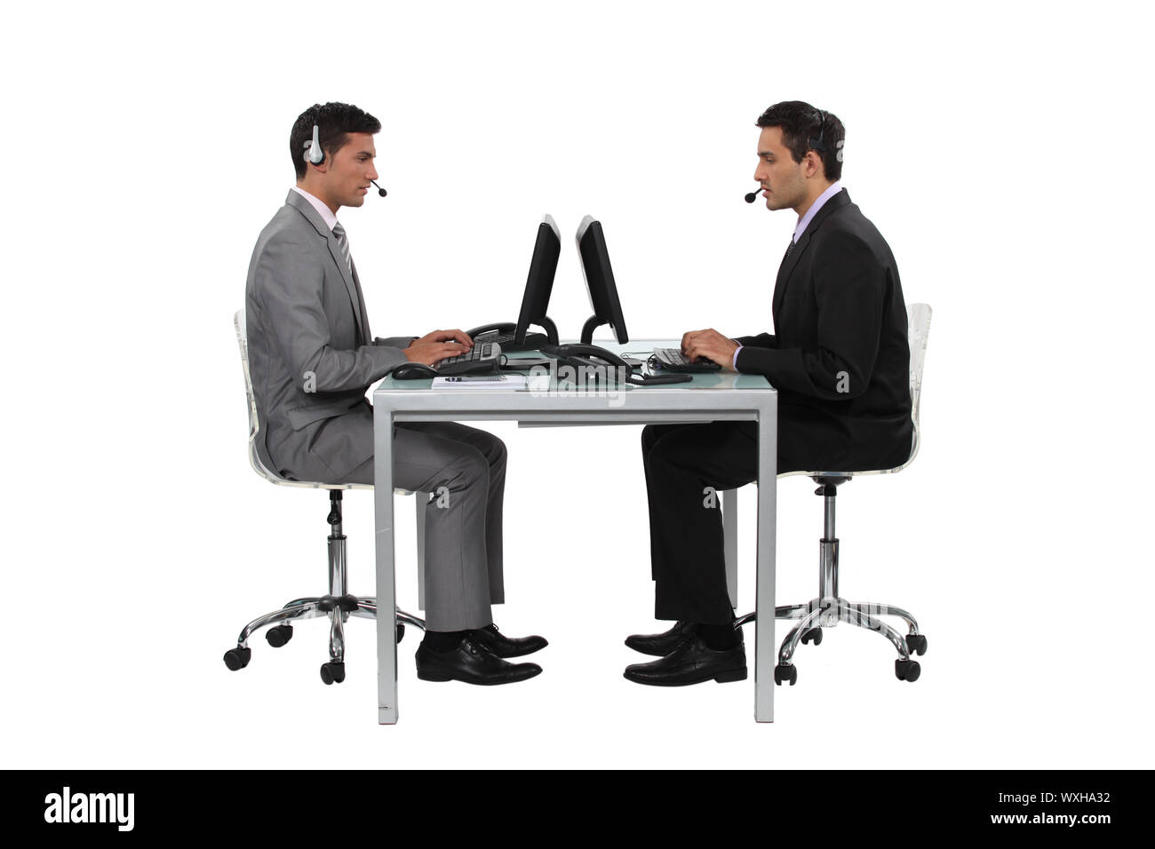two businessmen working at the same desk Stock Photo - Alamy
