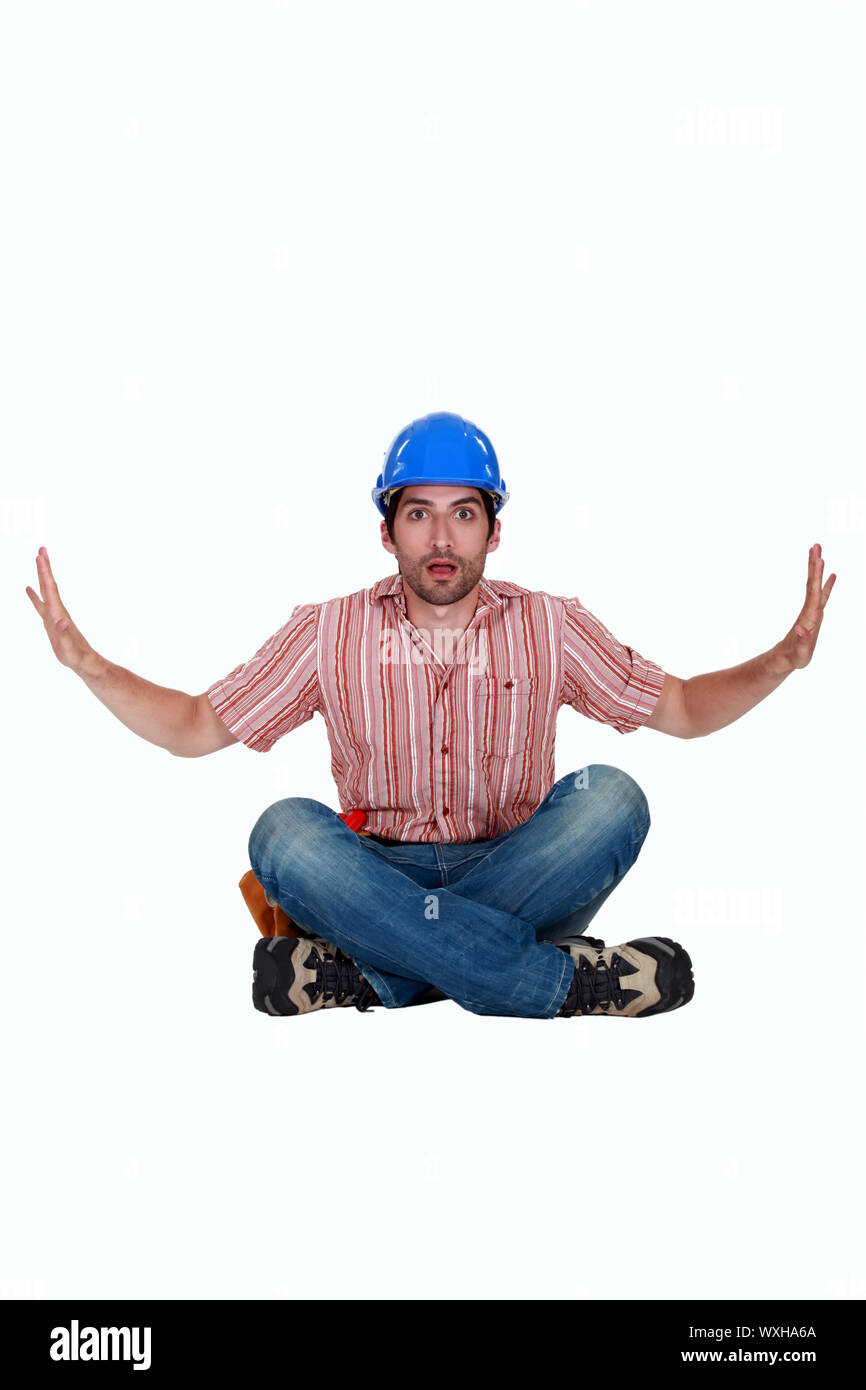 Surprised laborer sitting on white background Stock Photo - Alamy