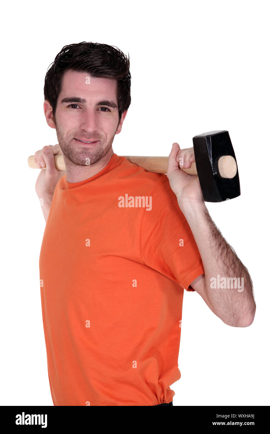 Man carrying sledge-hammer over shoulder Stock Photo - Alamy