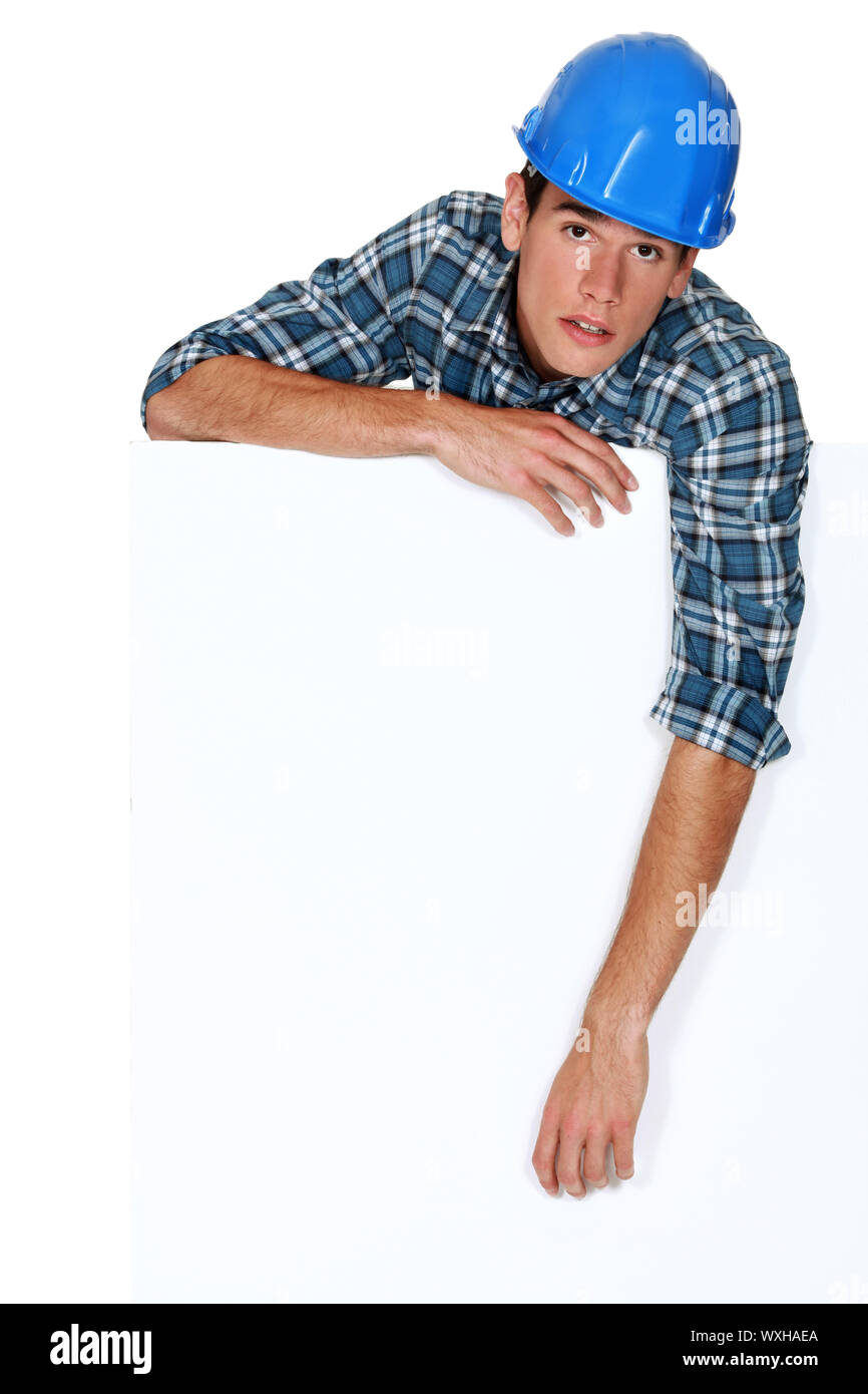 Tradesman leaning against a blank sign Stock Photo - Alamy