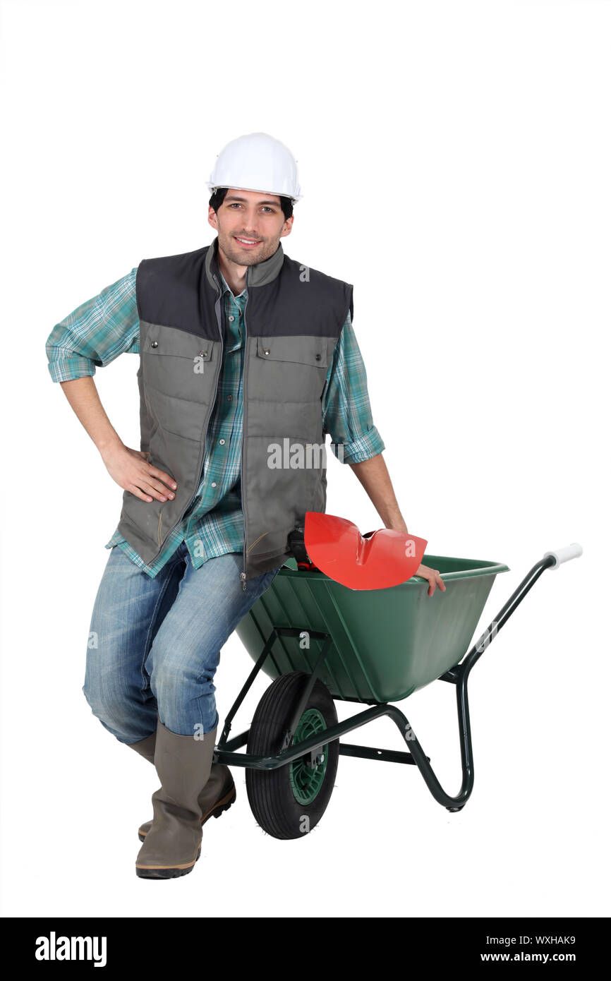 Labourer posing with a wheelbarrow and spade Stock Photo - Alamy