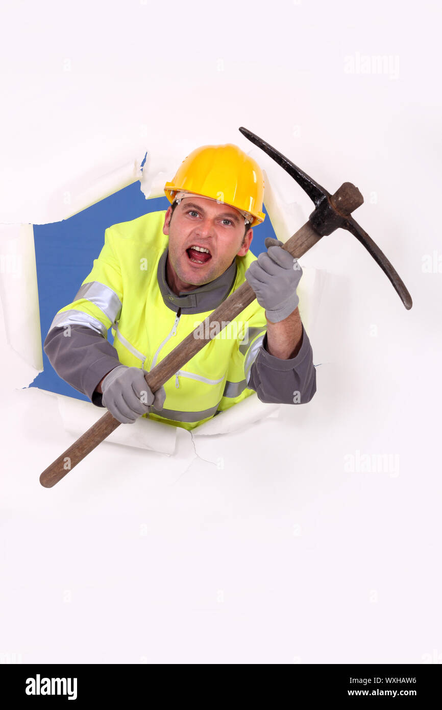 Construction worker breaking through a barrier with a pickaxe Stock ...