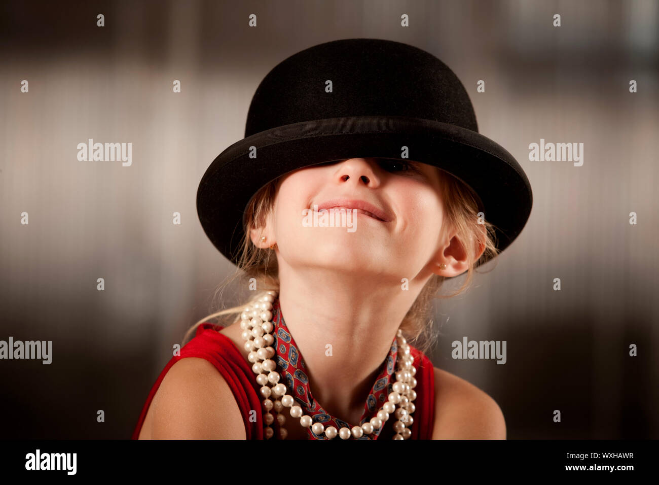 Funny young girl with her face hidden in her hat Stock Photo - Alamy