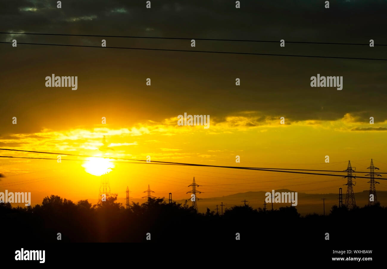 High voltage power lines in the sunrise Stock Photo - Alamy