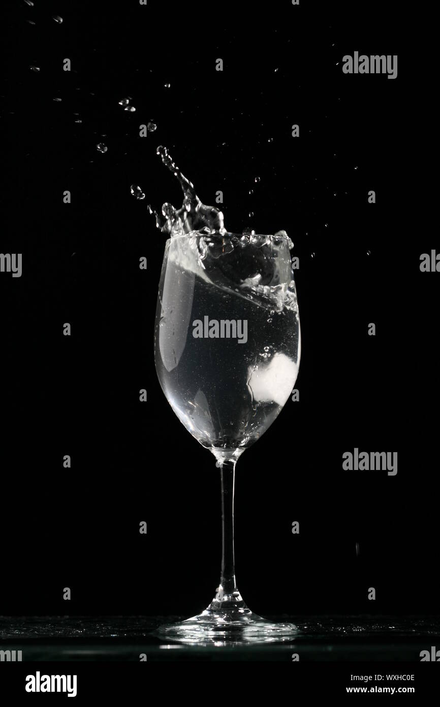 alcohol splash on black background Stock Photo - Alamy