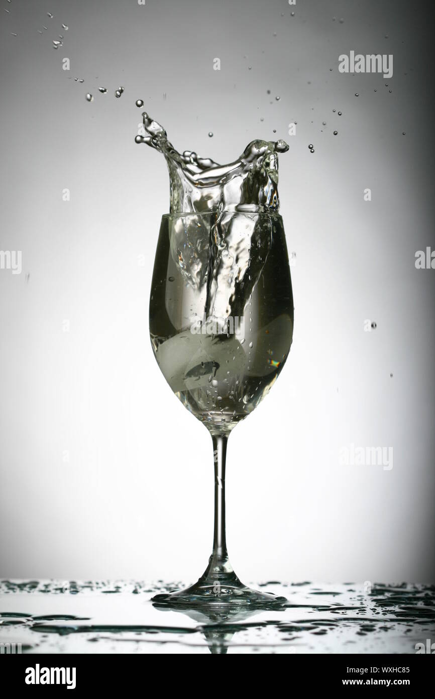 alcohol splash on gray background Stock Photo - Alamy