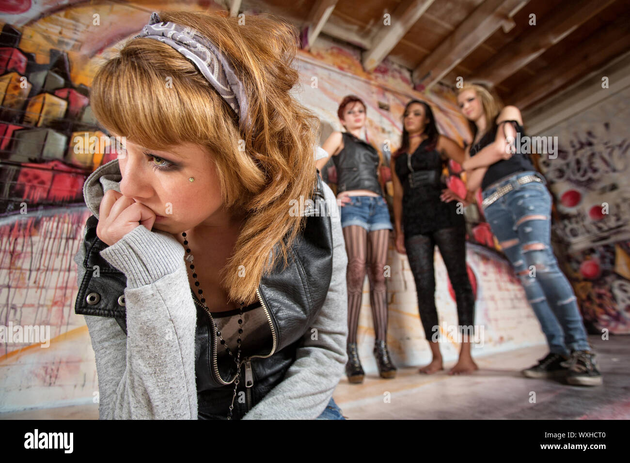 Lonely female being teased by group of people Stock Photo - Alamy