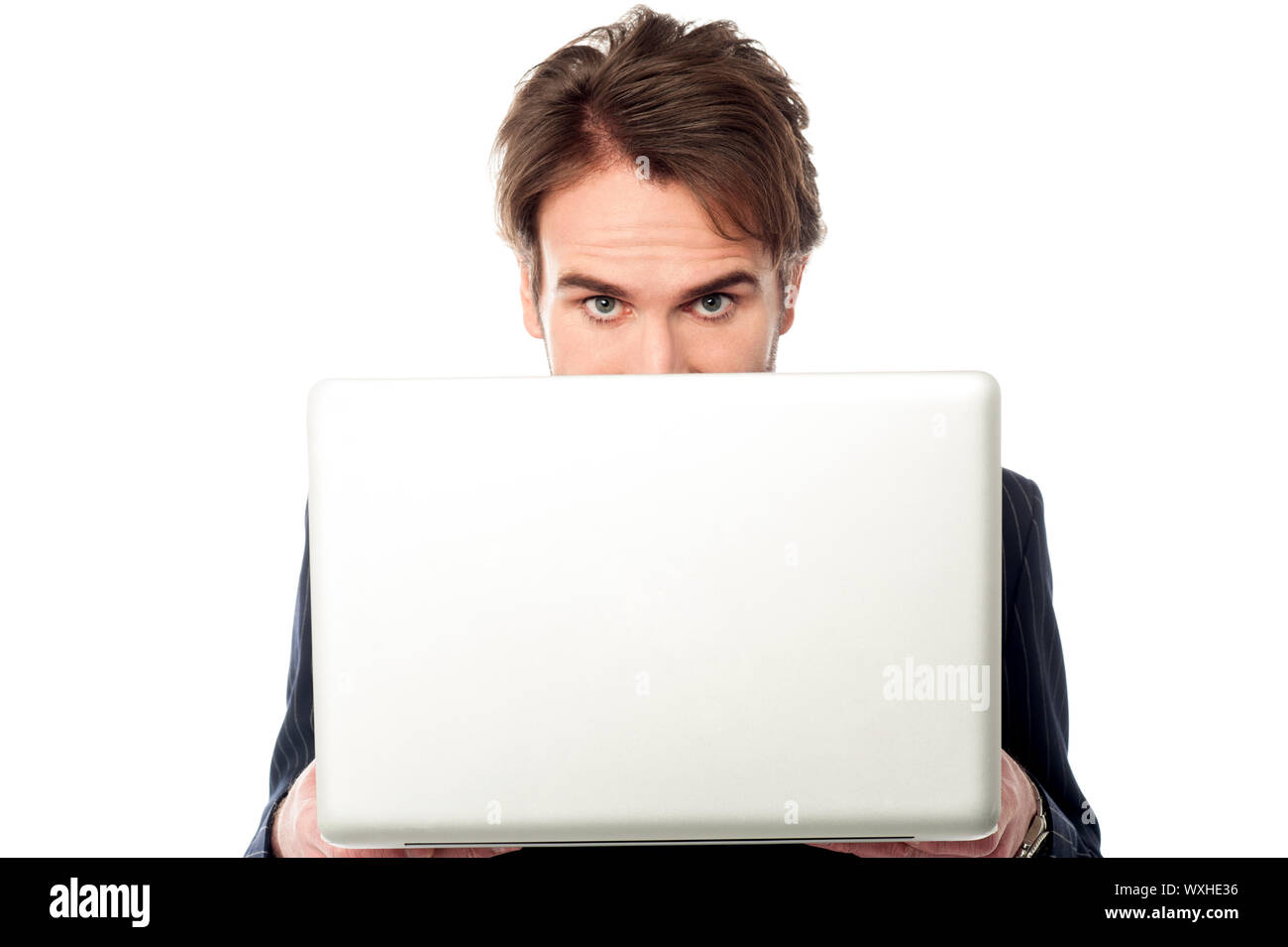 Serious male manager hiding face behind laptop Stock Photo - Alamy