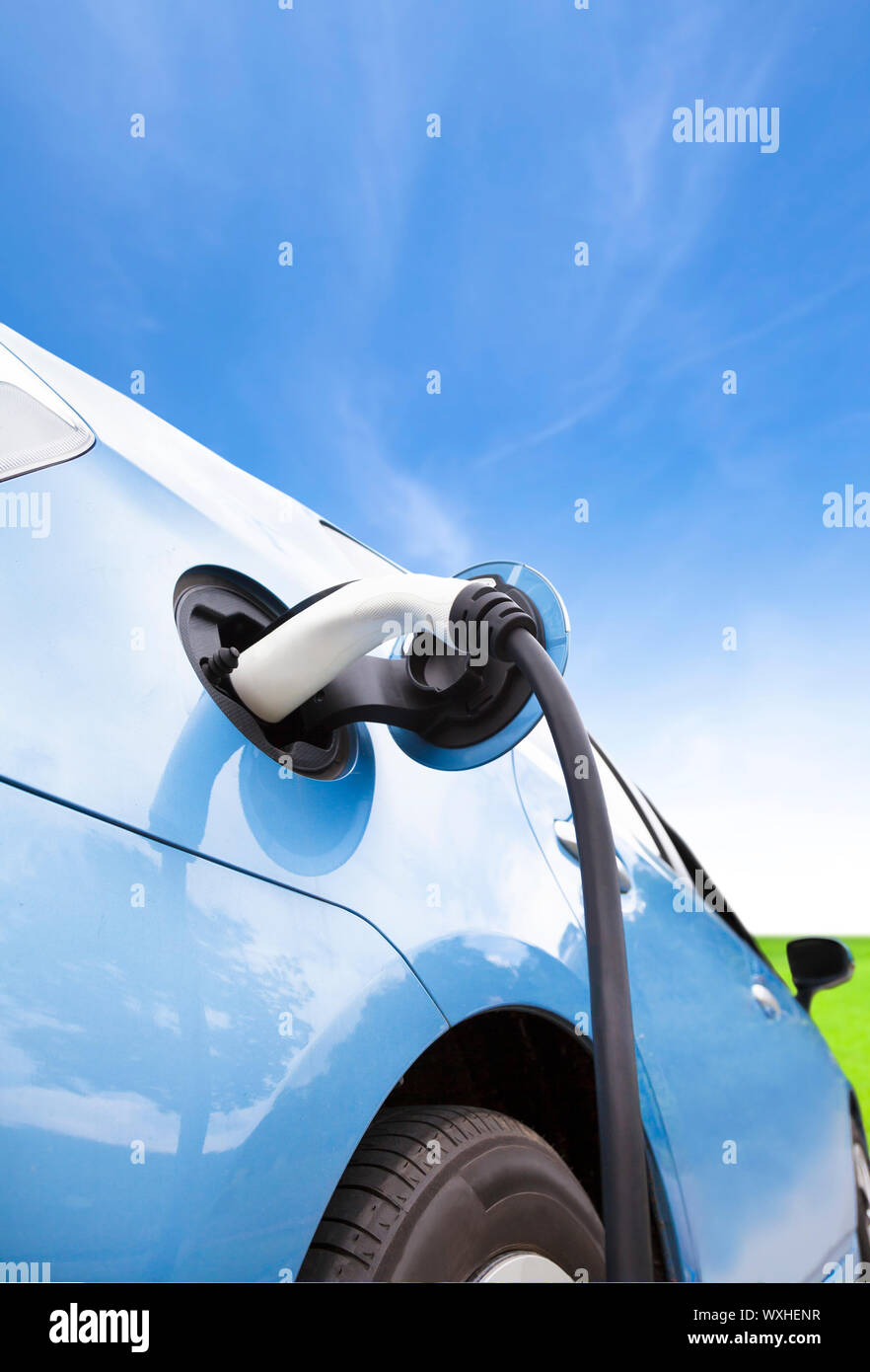 Charging of an electric car with cloud background Stock Photo - Alamy