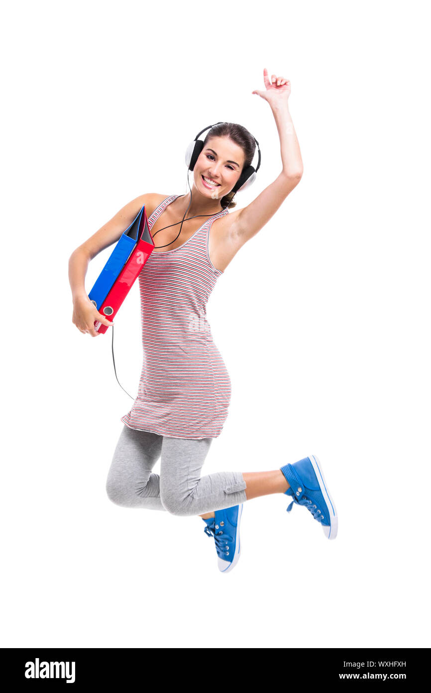 Beautiful student jumping with books and headphones, isolated over a ...
