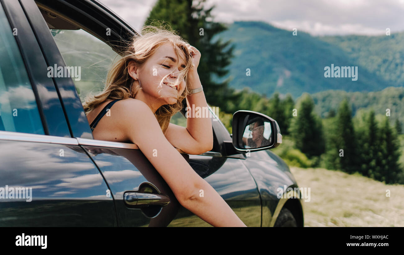 Happy woman travels by car in the mountains. Summer vacation concept ...