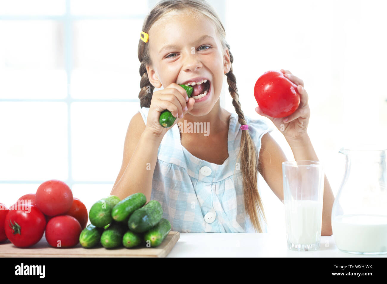 Child eating vegetables in the kitchen at home Stock Photo - Alamy
