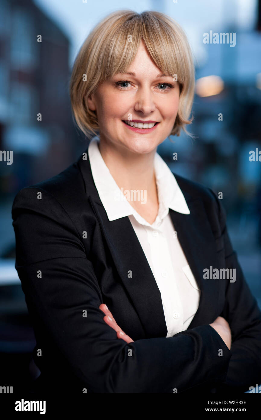 Smiling confident female manager posing with arms crossed Stock Photo ...