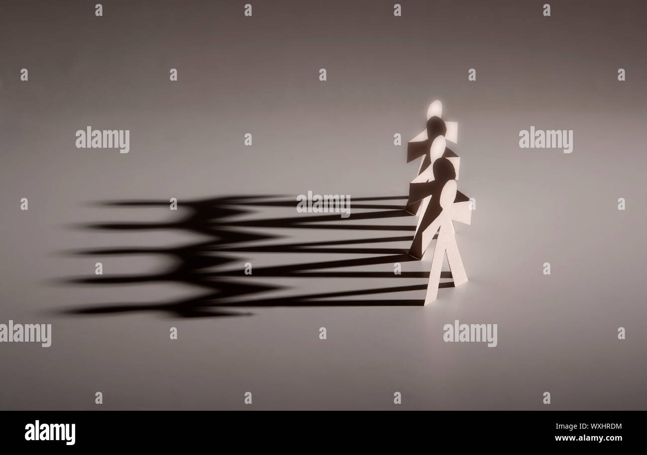 Line of cutout paper dolls throwing a shadow Stock Photo - Alamy