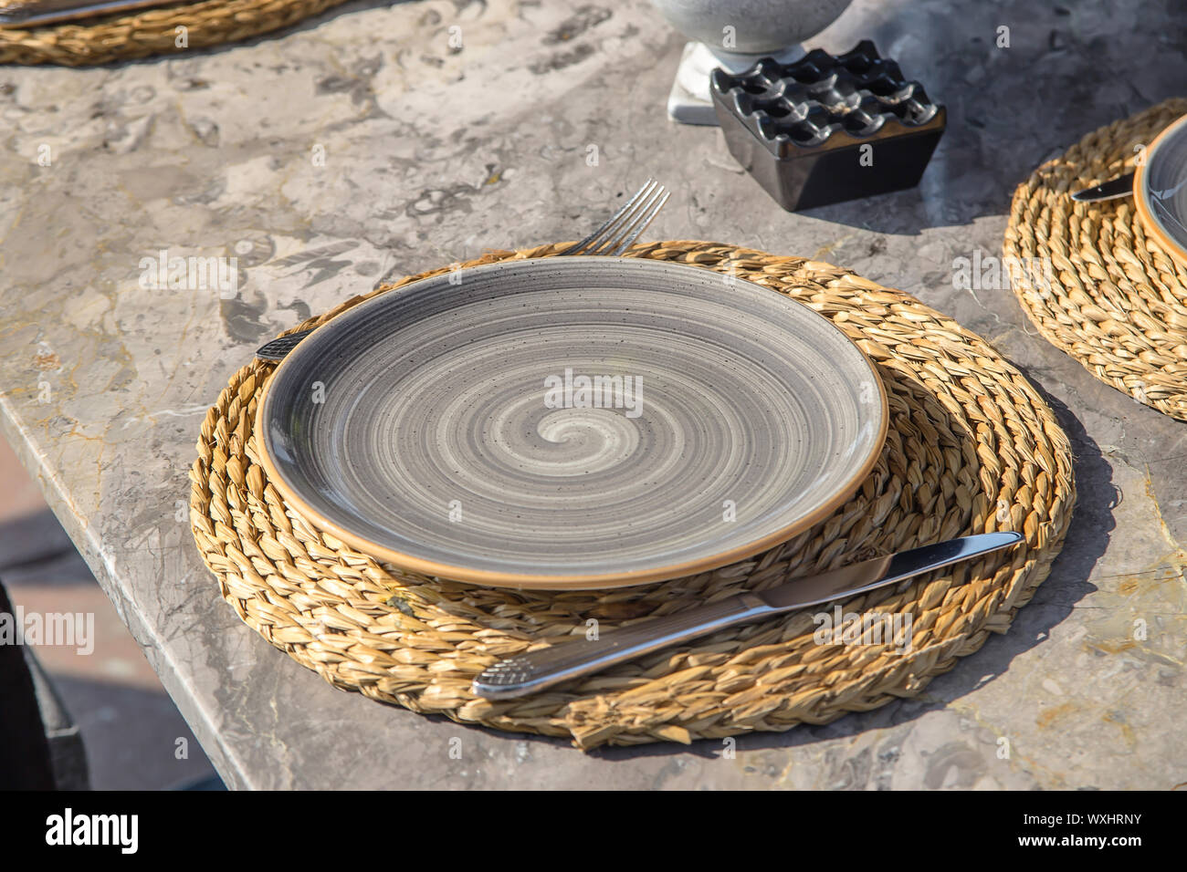 Minimalistic table setting outside on a straw substrate with a large ...
