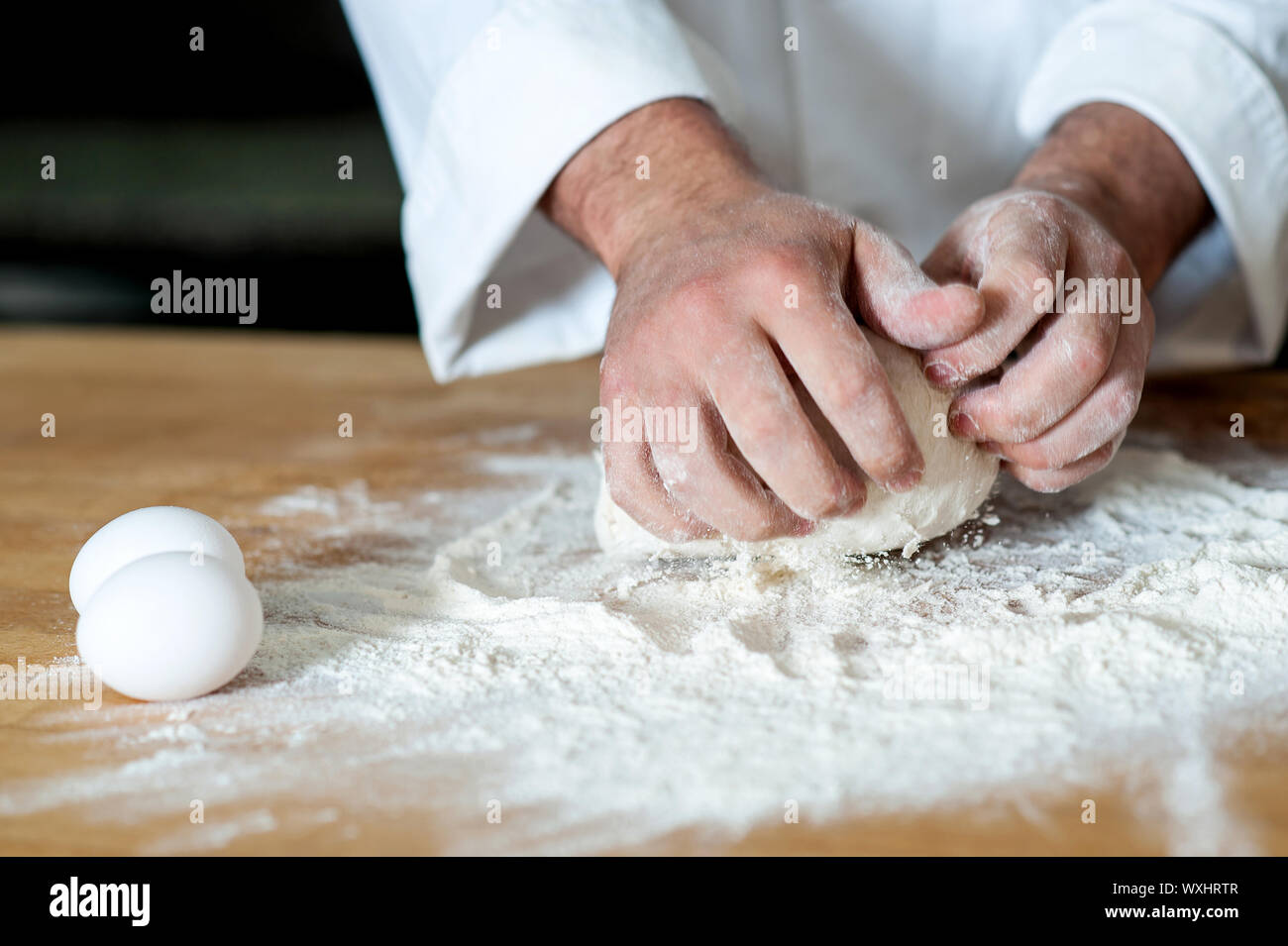 Human hands kneading dough with eggs beside Stock Photo - Alamy