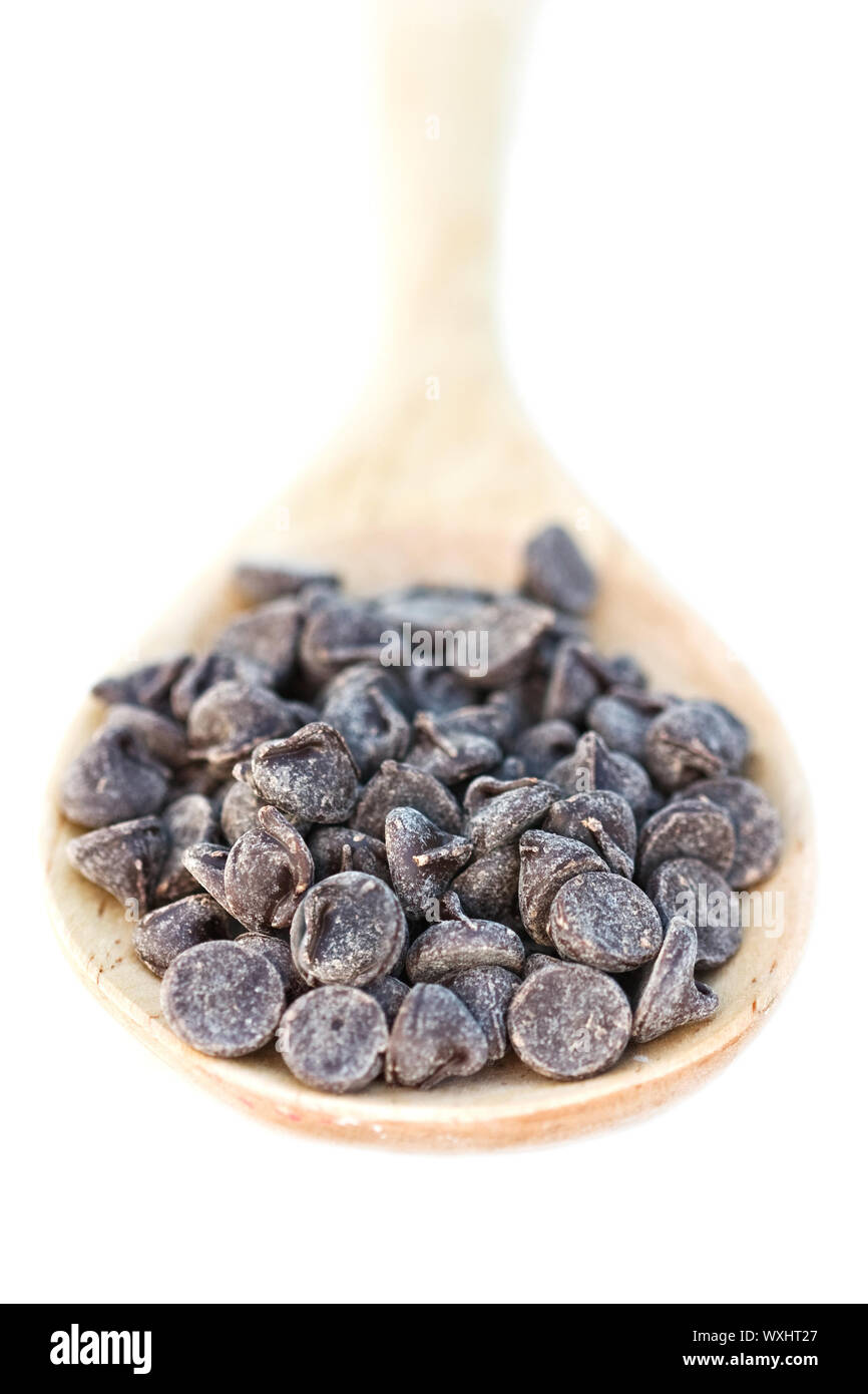 Wooden spoon full of chocolate chips isolated on a white background ...