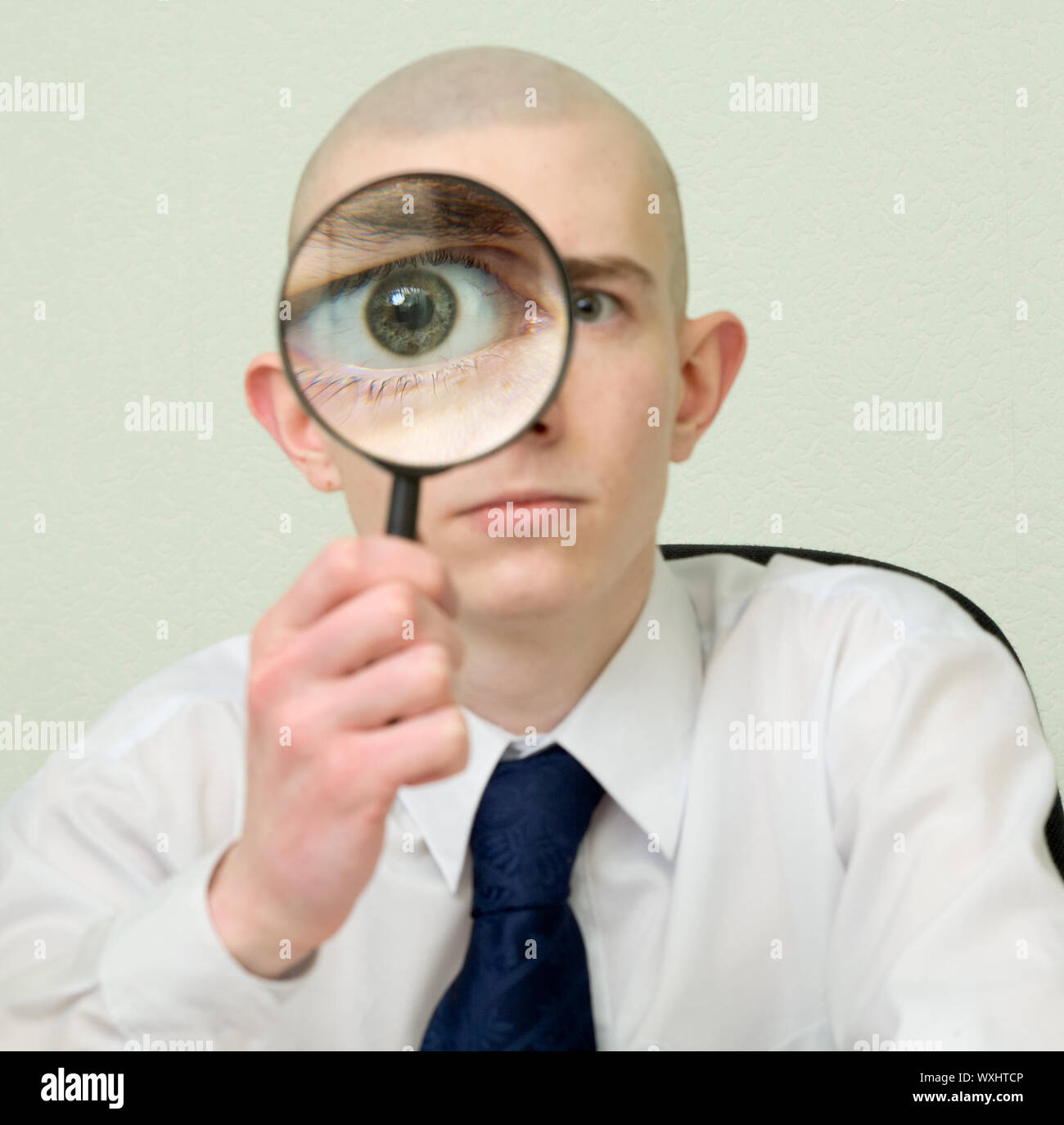 The guy looks through the big magnifier Stock Photo - Alamy