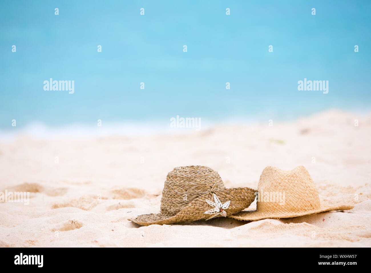 Two straw hats on white sand tropical beach Stock Photo - Alamy