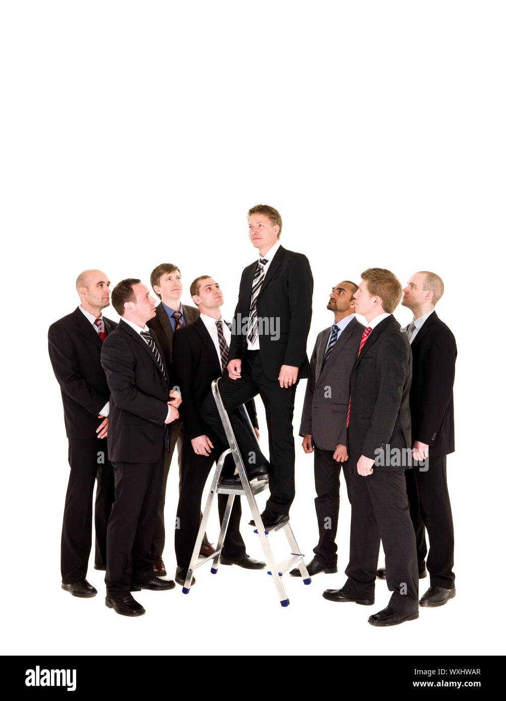 Manager standing on a step ladder with his team around Stock Photo - Alamy