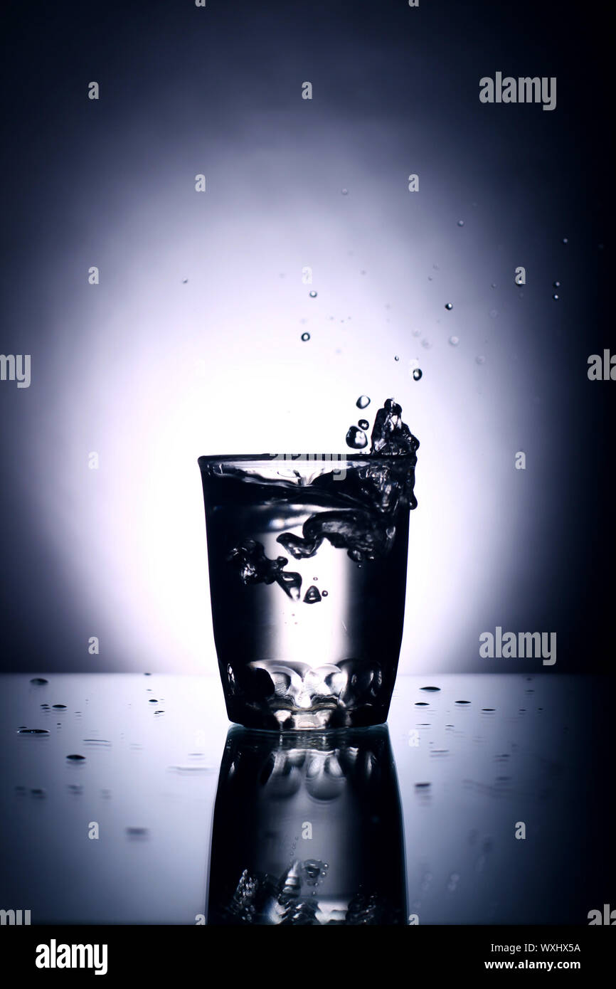 alcohol splash on gray background Stock Photo - Alamy
