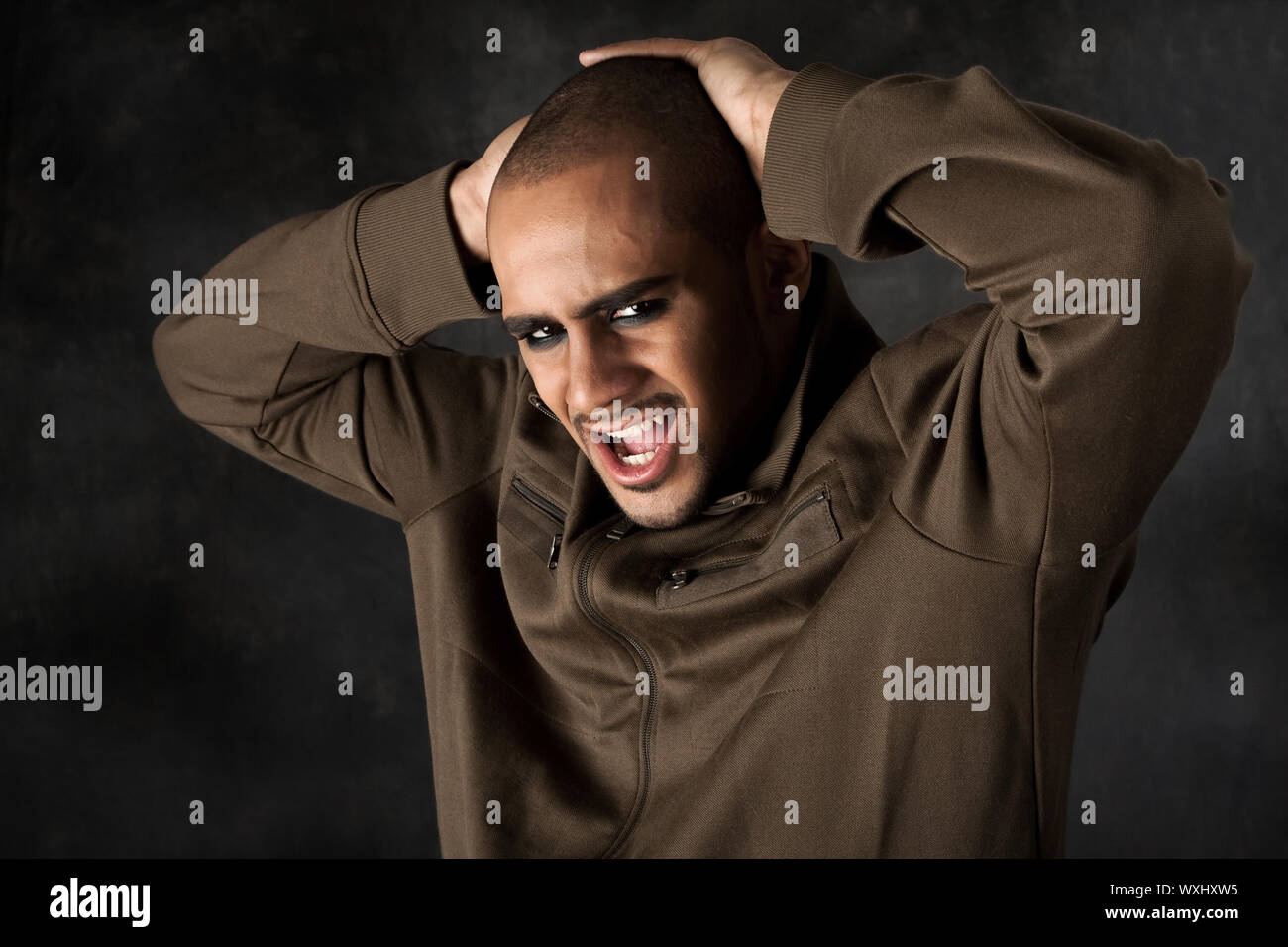 Handsome African Hispanic guy frowning with strong mad macho expression ...