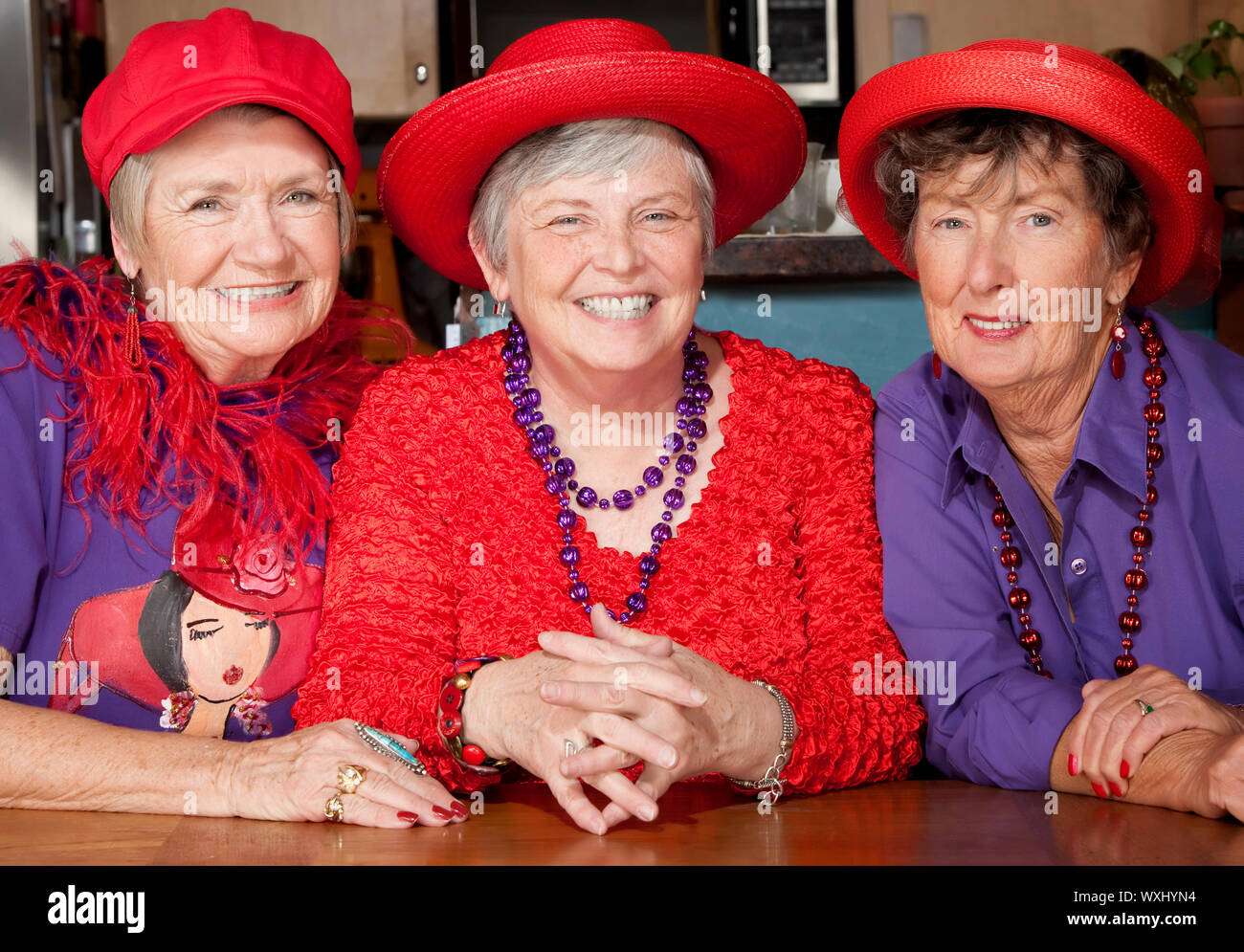 Three friendly senior women wearing red hats Stock Photo - Alamy