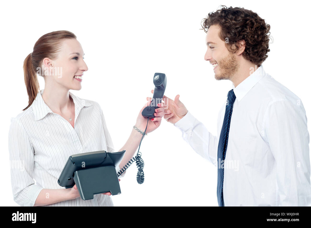 Secretary handing over phone receiver to her boss Stock Photo - Alamy