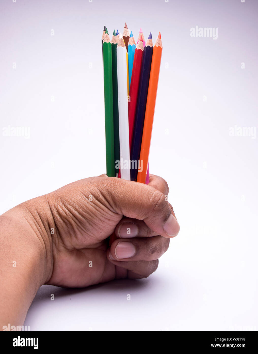 Hand holding bunch of colored pencils together Stock Photo - Alamy