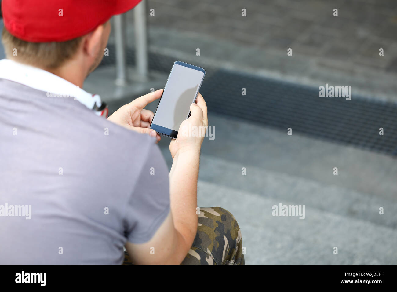 Guy sitting on stairs with cellphone Stock Photo - Alamy