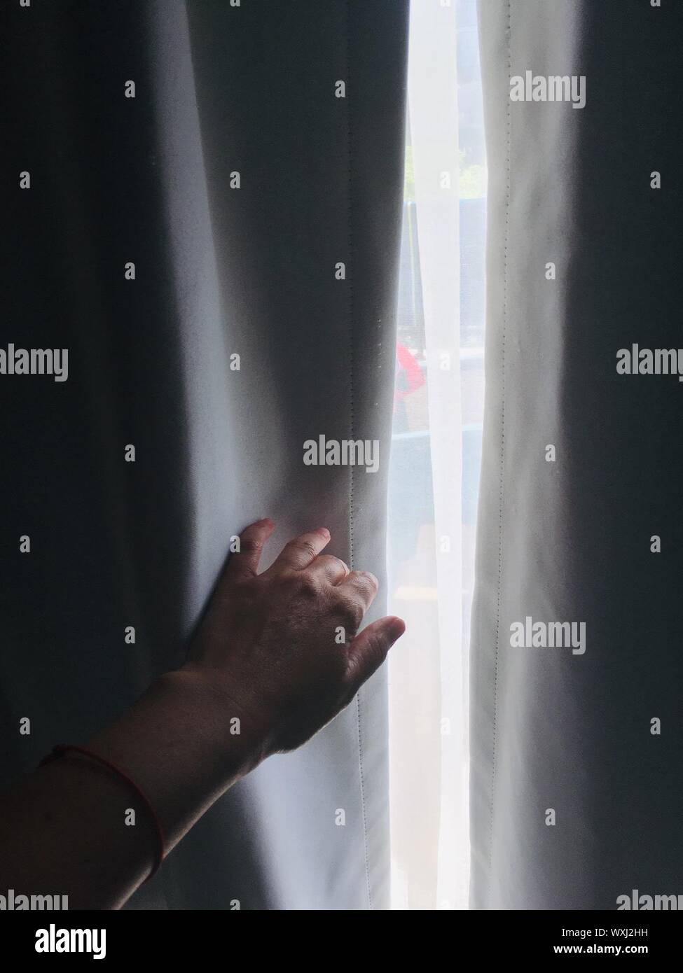 Woman's hand moving curtain away from the window Stock Photo - Alamy
