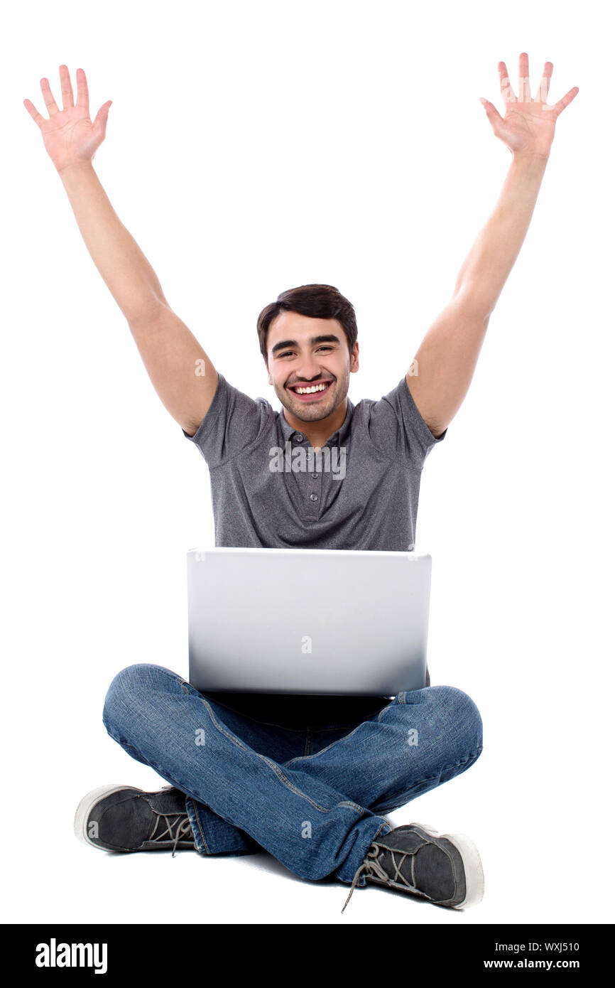 Guy with laptop on his lap, raising arms up Stock Photo - Alamy