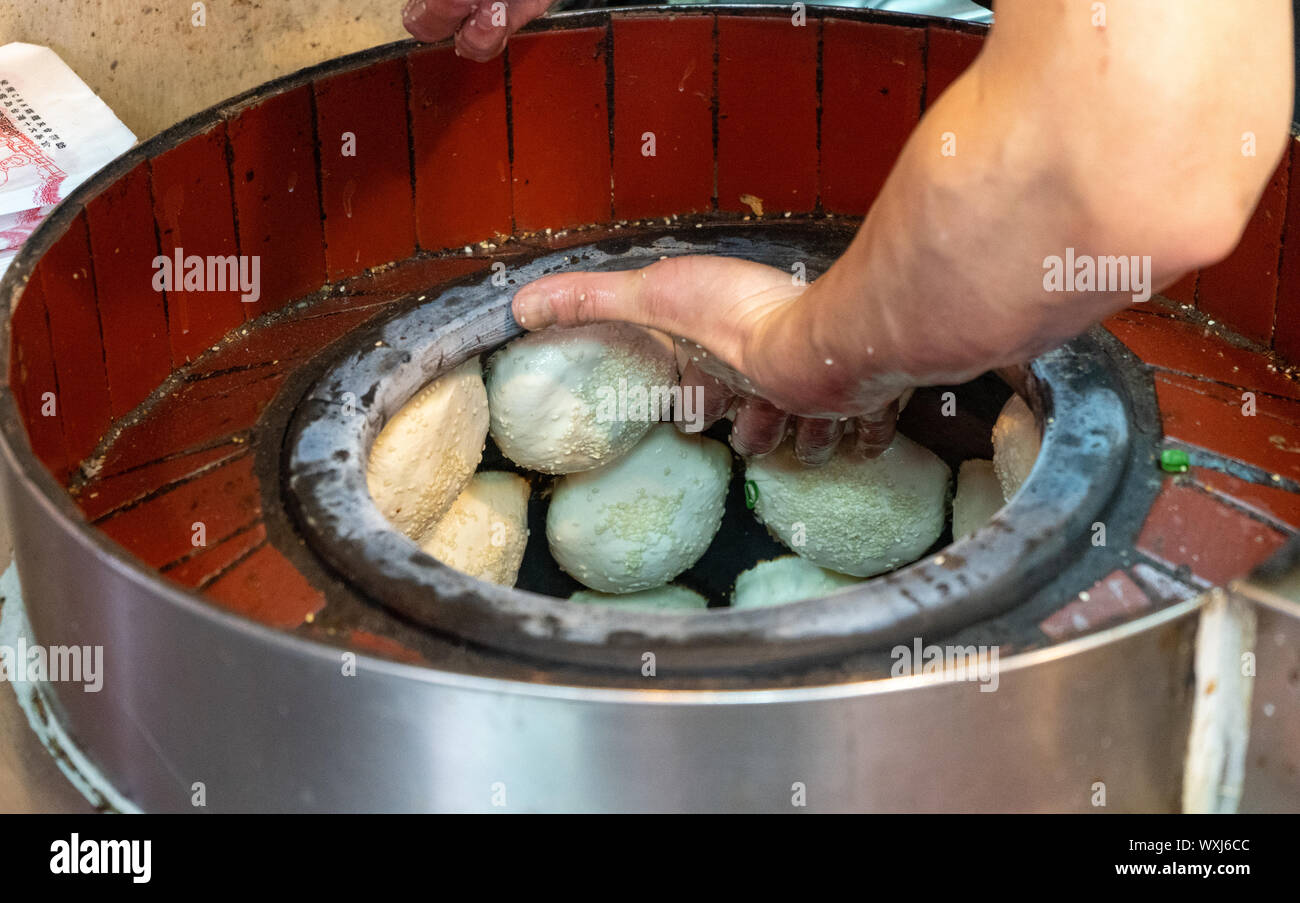 Taipei, Taiwan: Hand sticking Raw Pepper Pork Buns on wall inside a ...