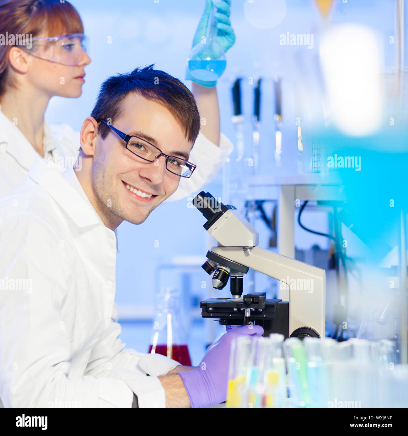 Portrait of a young male researcher microscoping in the life science ...