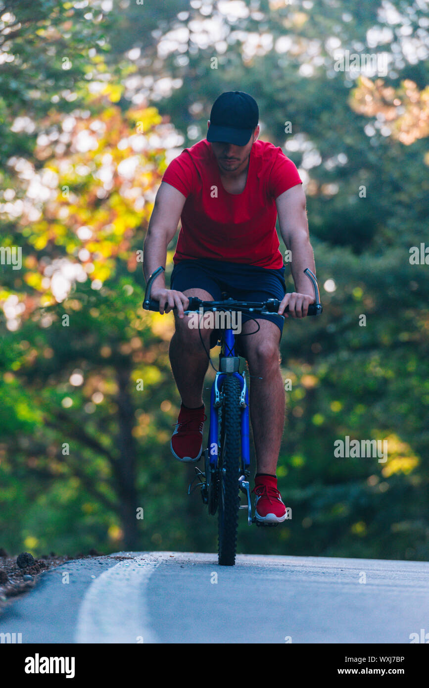 Tall handsome biker rides his bicycle on sunset in a lovely magical ...
