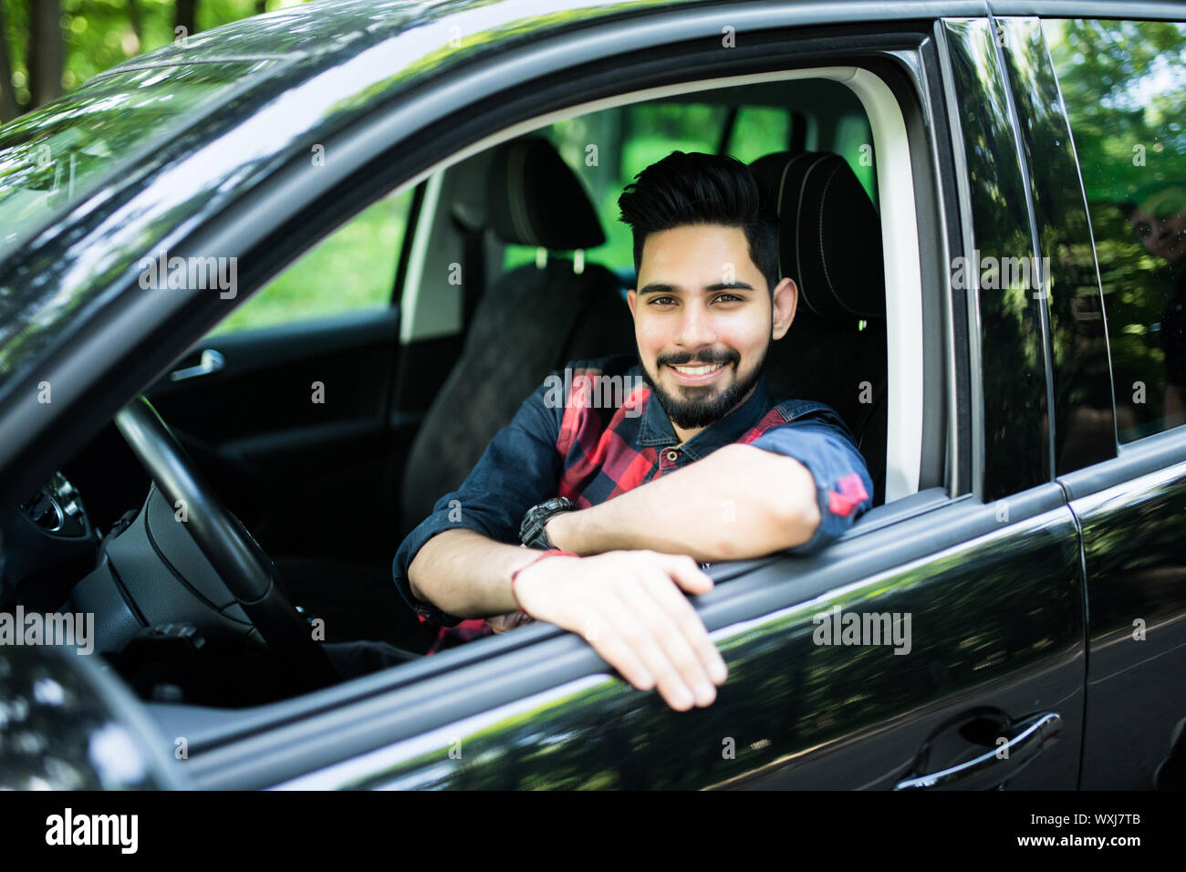 A handsome Indian man in a saloon car outside in countryside Stock ...