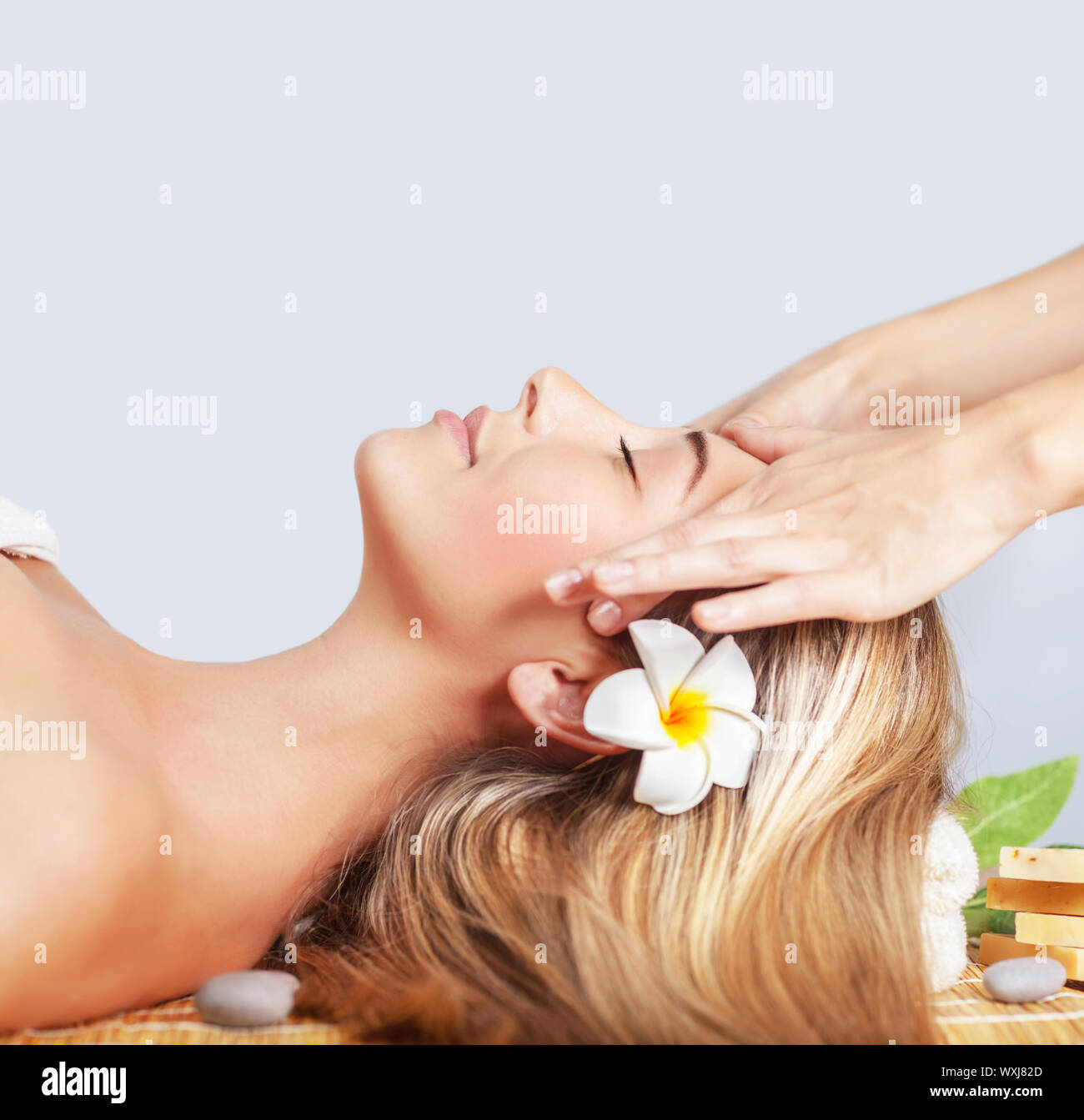 Closeup on beautiful blond woman lying down on massage table, side view ...