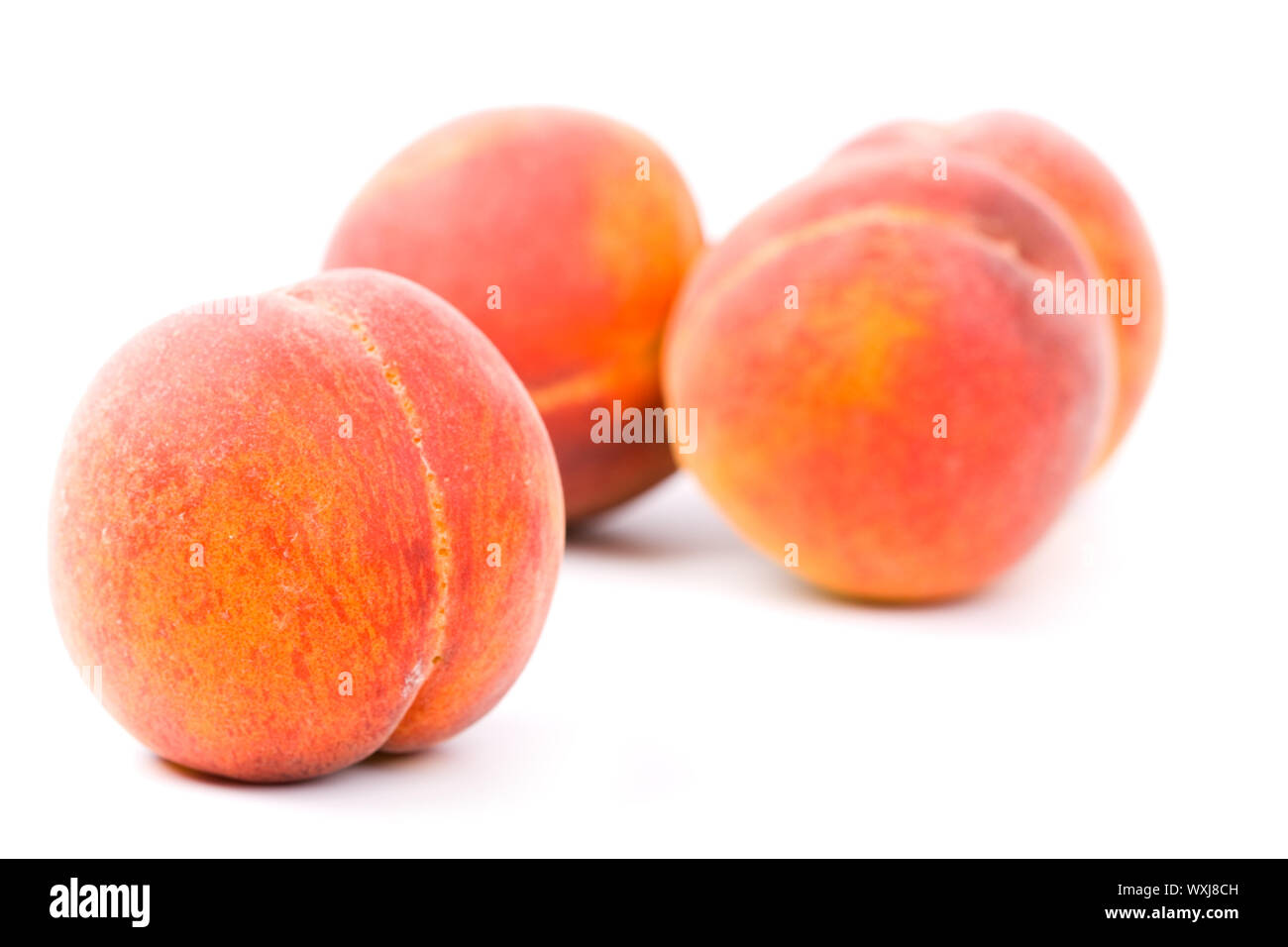 four peaches on white background Stock Photo - Alamy
