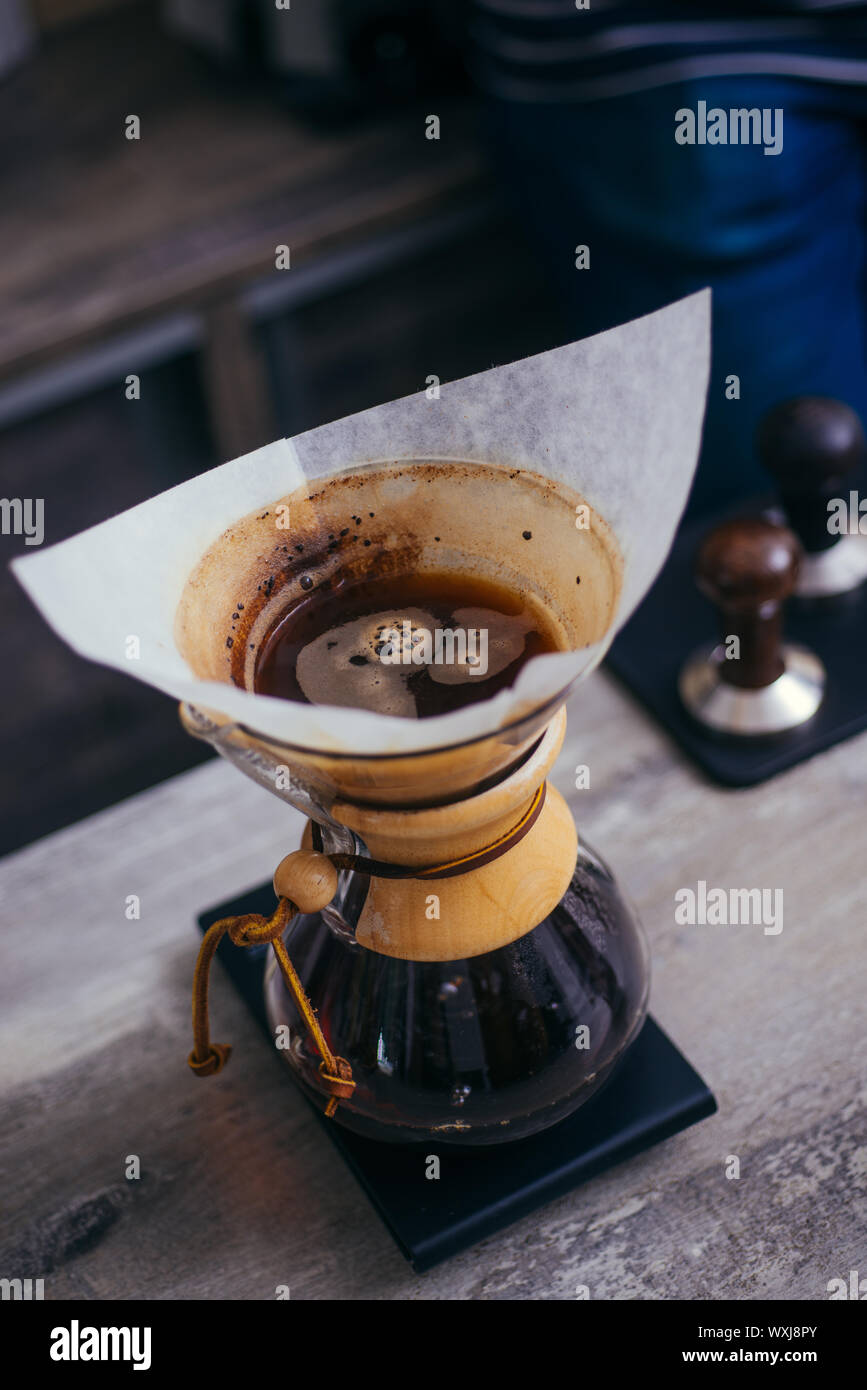 Coffee brewed in the filter paper. Drip Coffee Maker. Wooden background ...