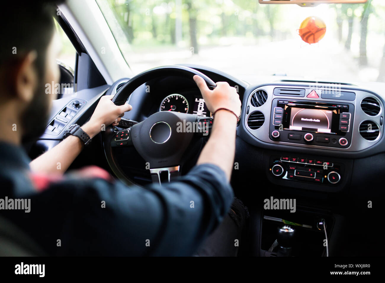 Businessman in car. Rear view of young handsome man looking on the ...