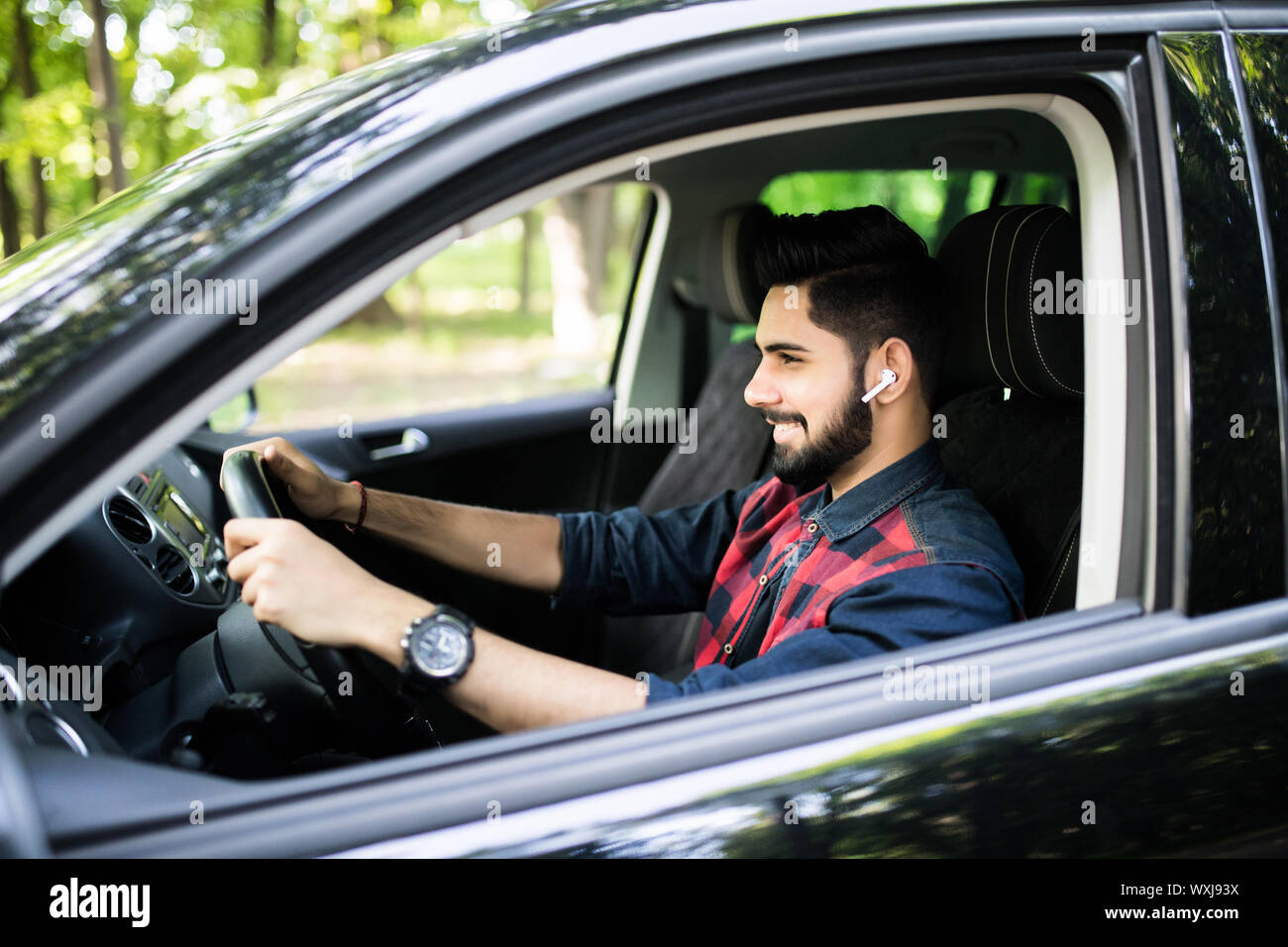A handsome Indian man in a saloon car outside in countryside Stock ...