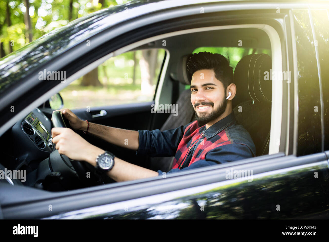 A handsome Indian man in a saloon car outside in countryside Stock ...