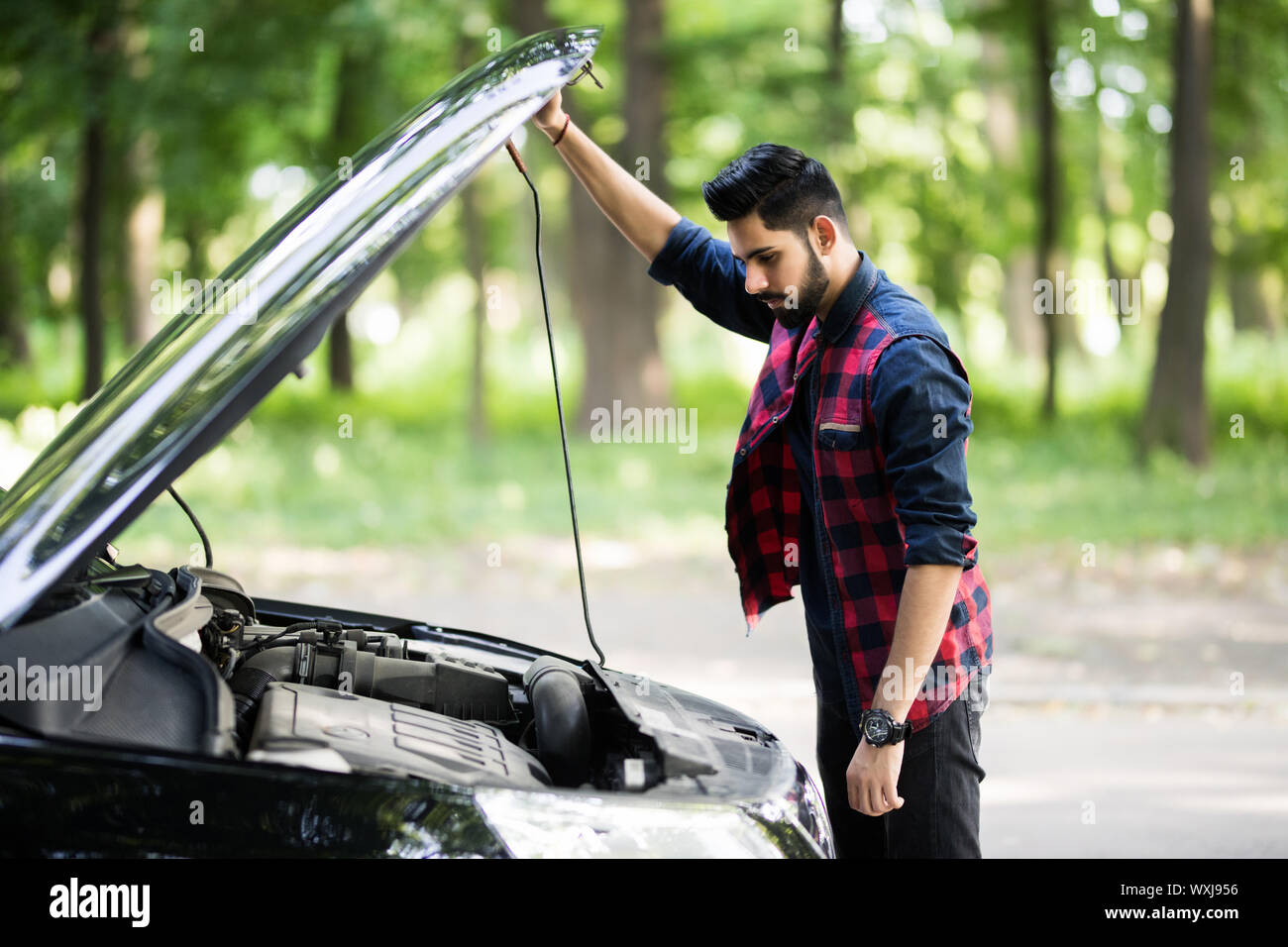 Man looking at engine of car Stock Photo - Alamy