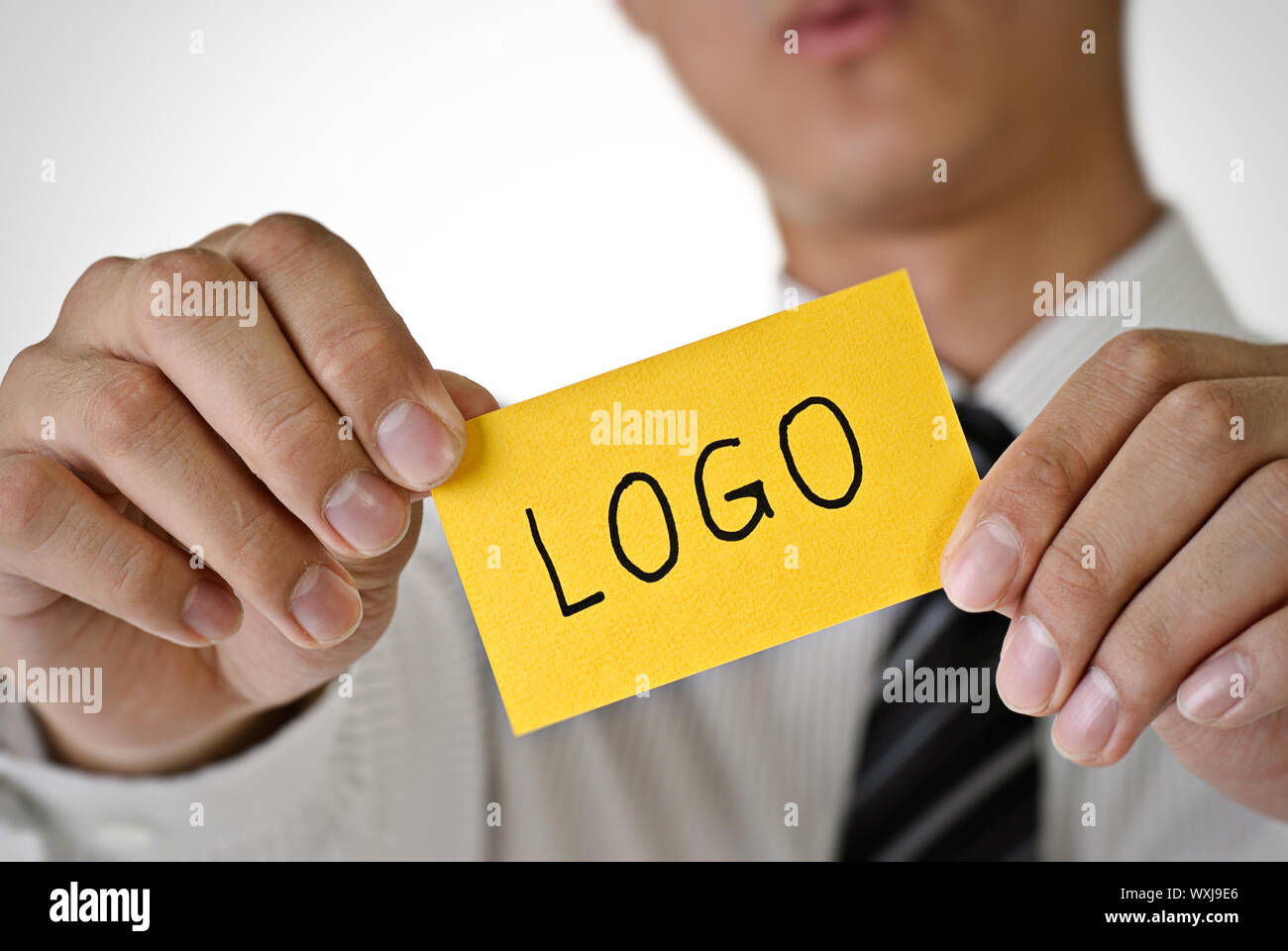 Logo words on yellow card hold by business man Stock Photo - Alamy